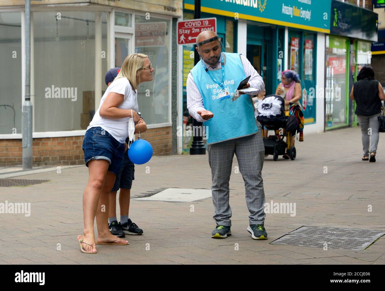 Chugger presenting to a passerby, during post lockdown Stock Photo - Alamy