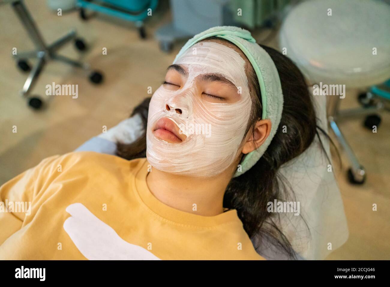 Young Asian female teenager getting her acne and facial treatment with ...