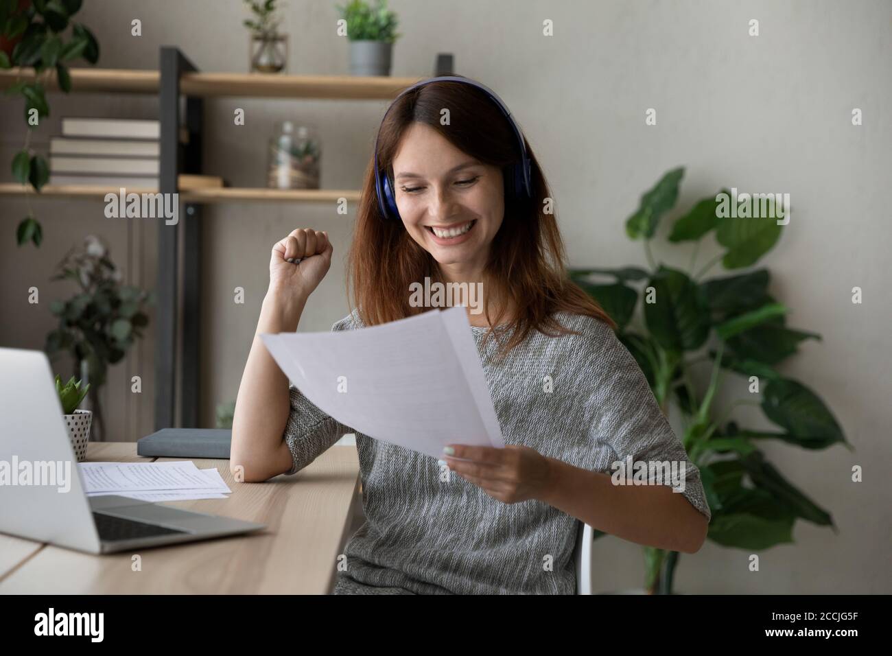 Exited young woman triumph reading paper letter Stock Photo - Alamy