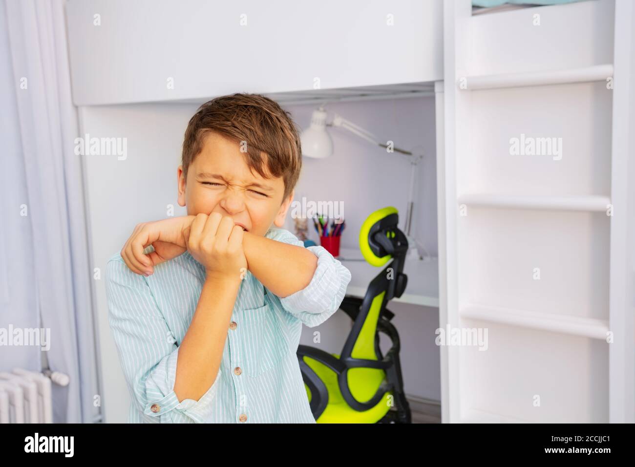 Close portrait of little autistic boy bite hands with strong negative ...
