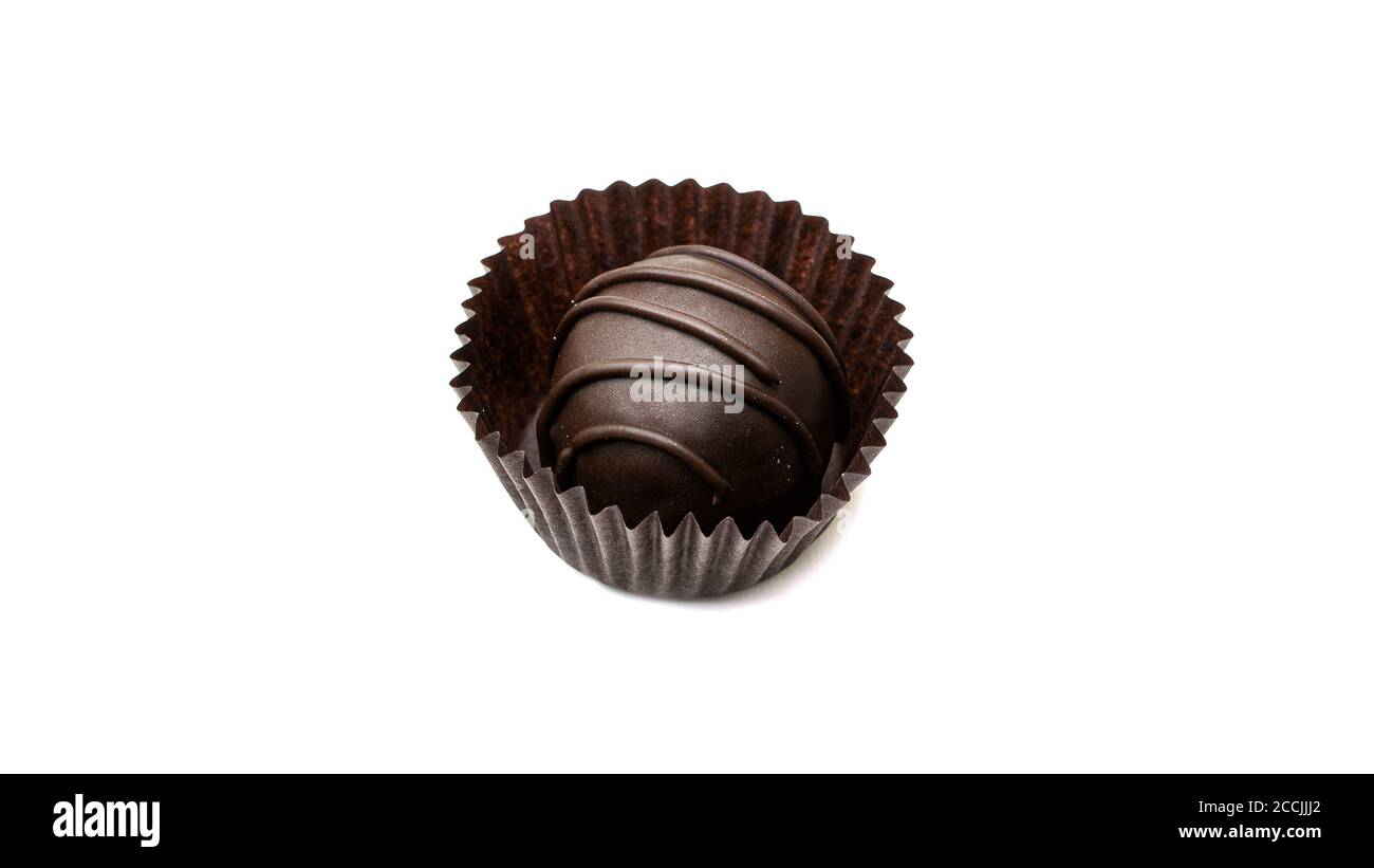 Delicious, round, chocolate candy in wrapper with nuts on a white ...