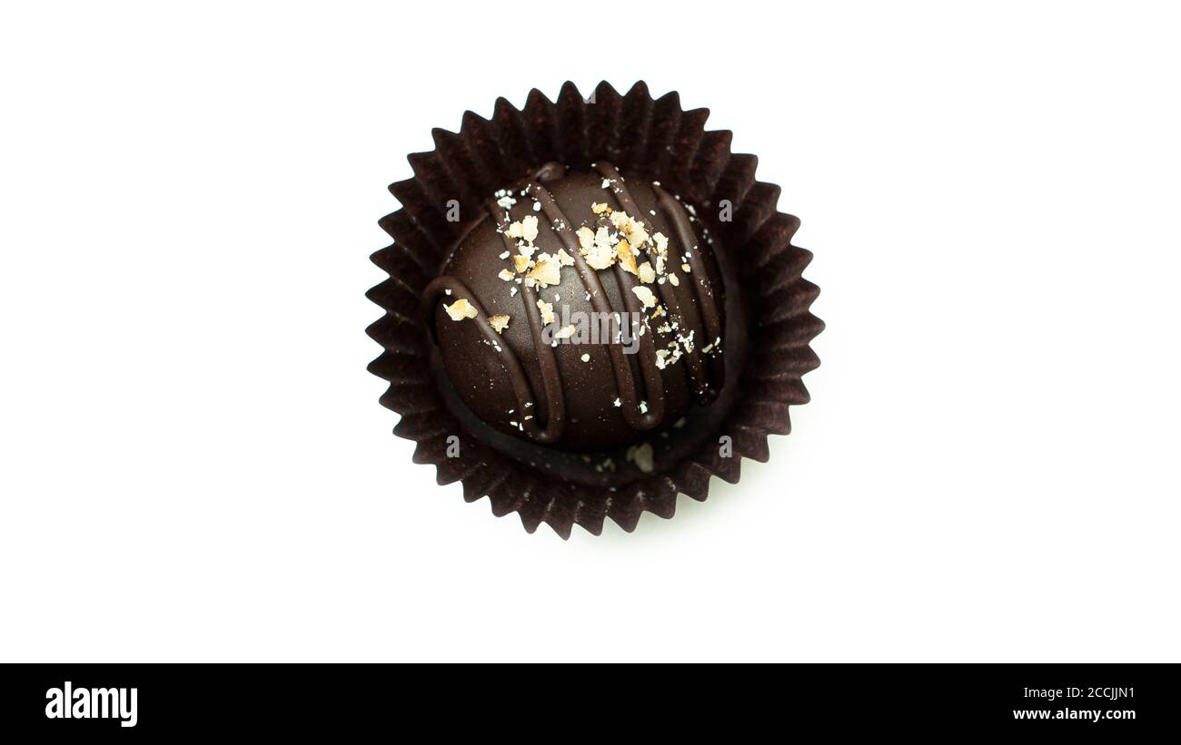 Delicious, round, chocolate candy in wrapper with nuts on a white ...