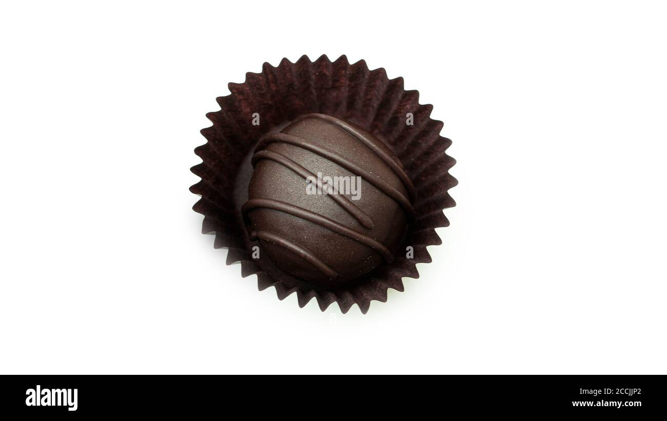 Delicious, round, chocolate candy in wrapper with nuts on a white ...