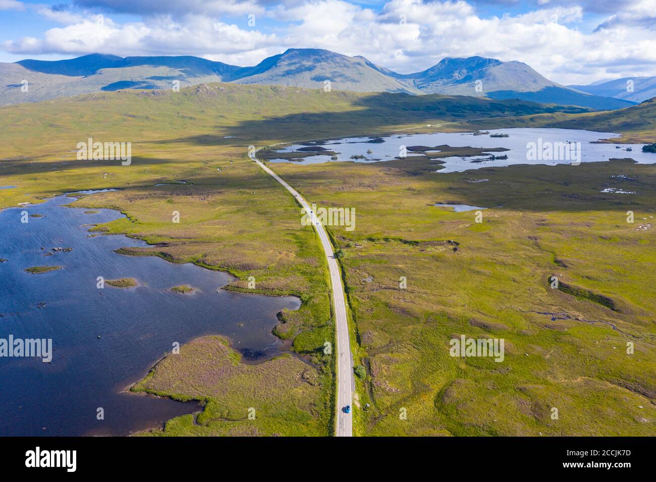 Aerial view of A82 road crossing Rannoch Moor in summer with Loch Ba on ...