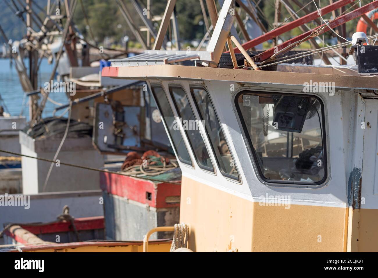 A fishing trawler boat cabin in the foreground and behind it outriggers ...