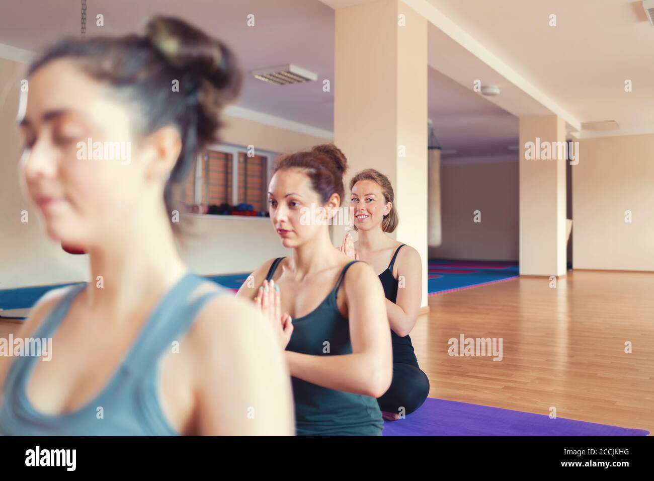 Young women doing meditation in yoga class Stock Photo - Alamy