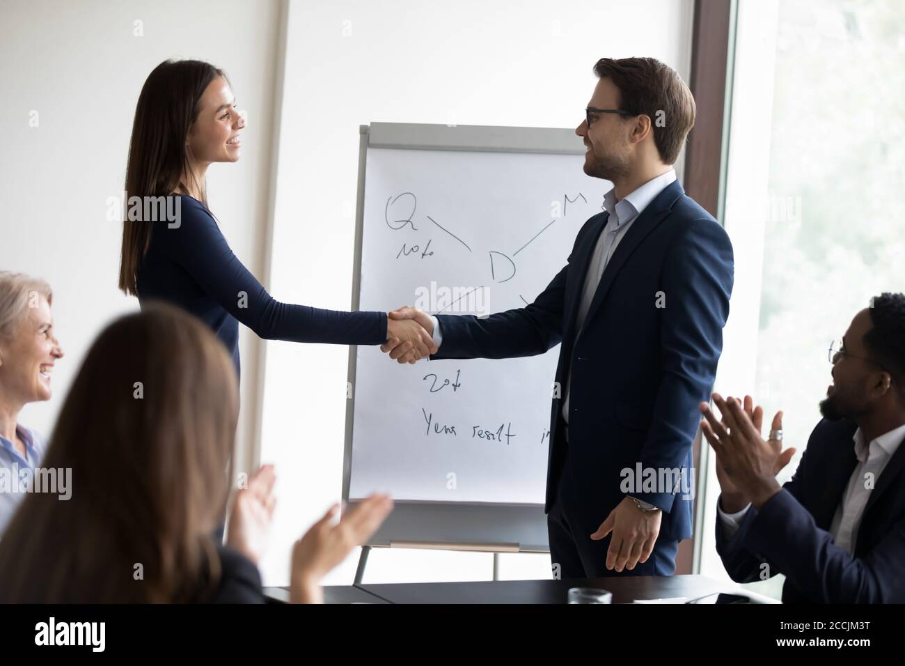 Young smiling ceo welcoming new teammate on corporate meeting Stock ...