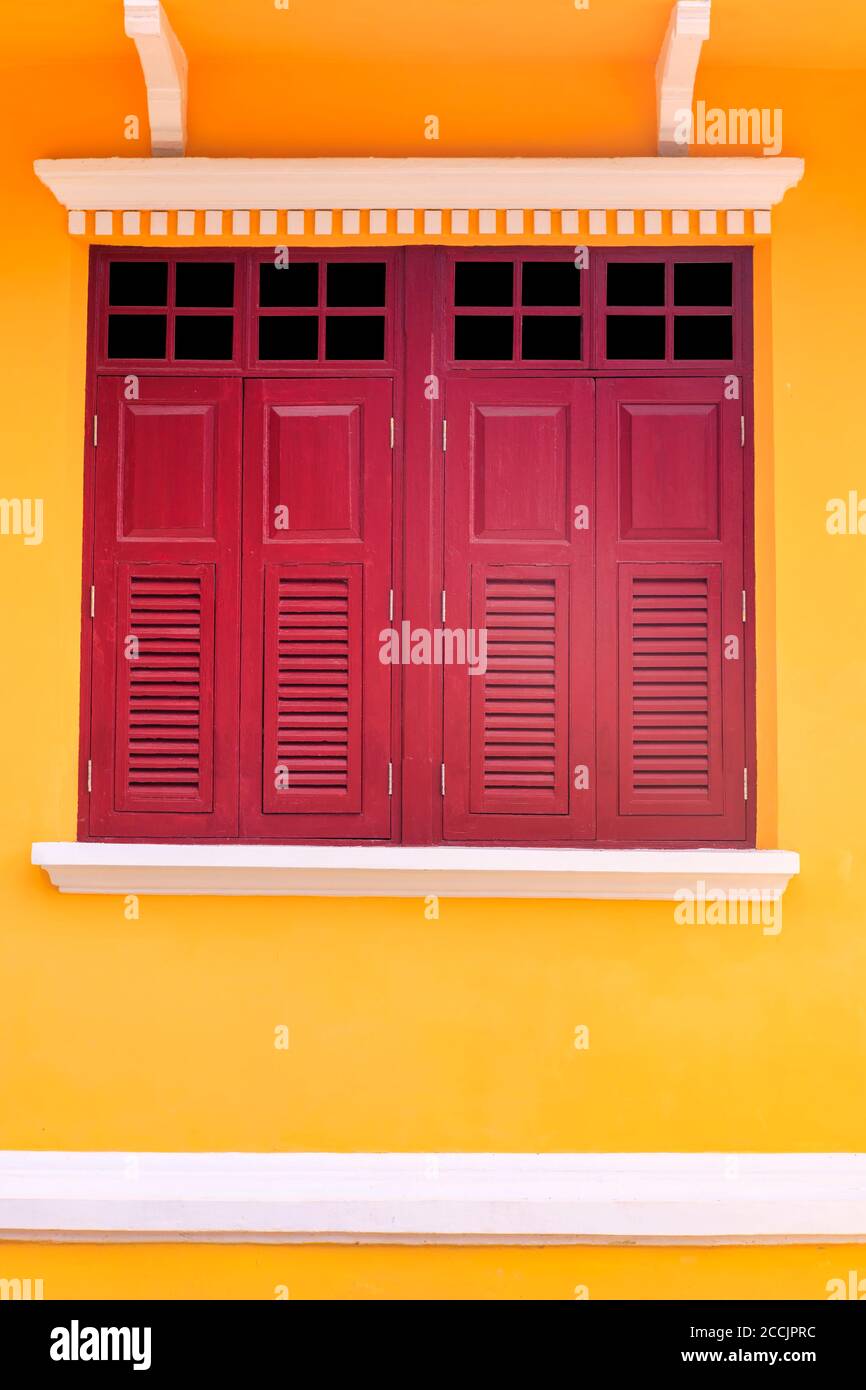 Old twin wood windows with yellow wall background. Old style double ...