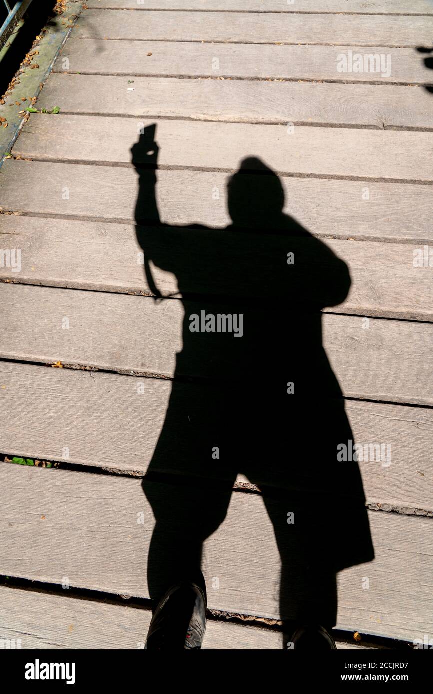 Shadow selfie, person takes a selfie, photo of himself, with a ...