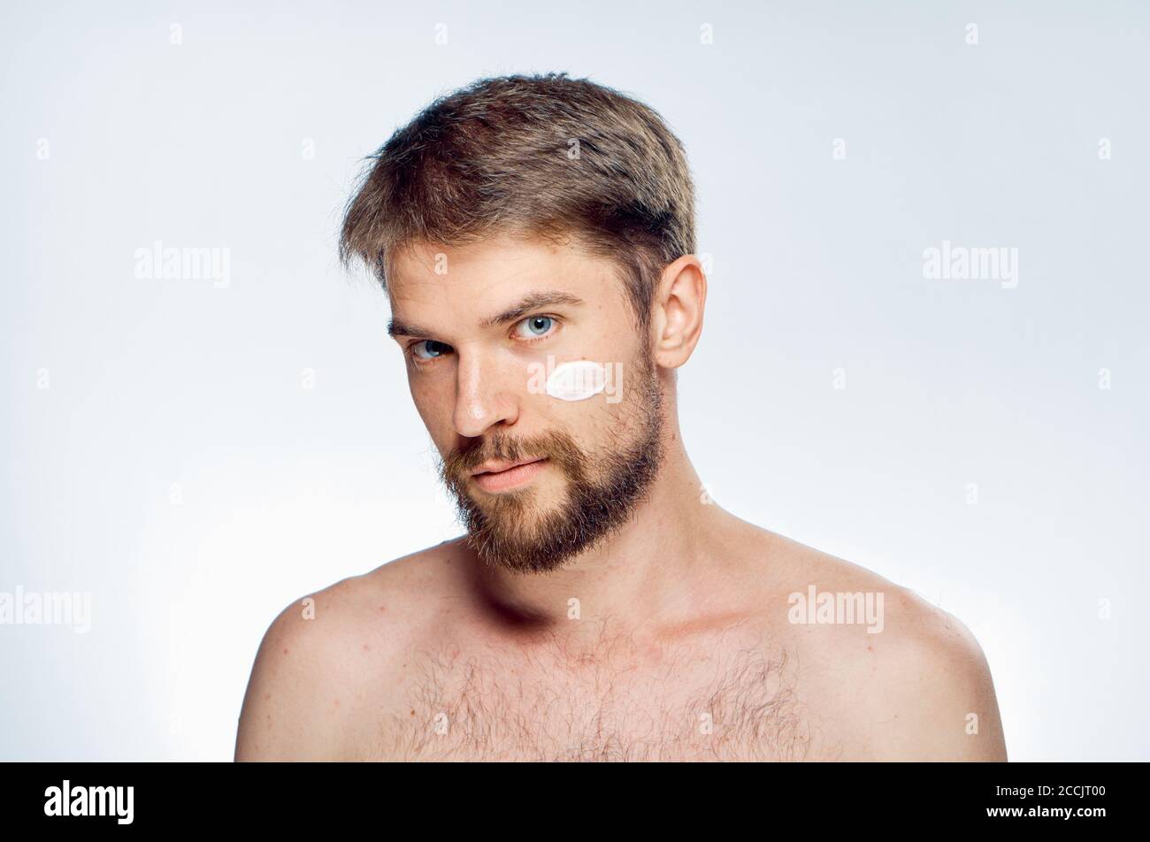 Bearded man face cream clean skin bare shoulders Stock Photo - Alamy