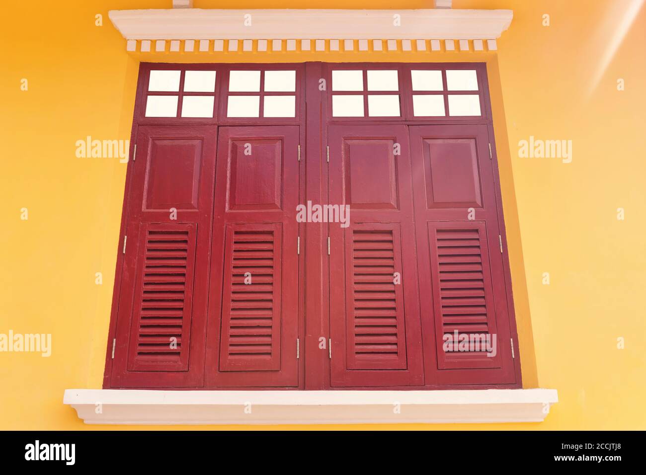 Old twin wood windows with yellow wall background. Old style double ...