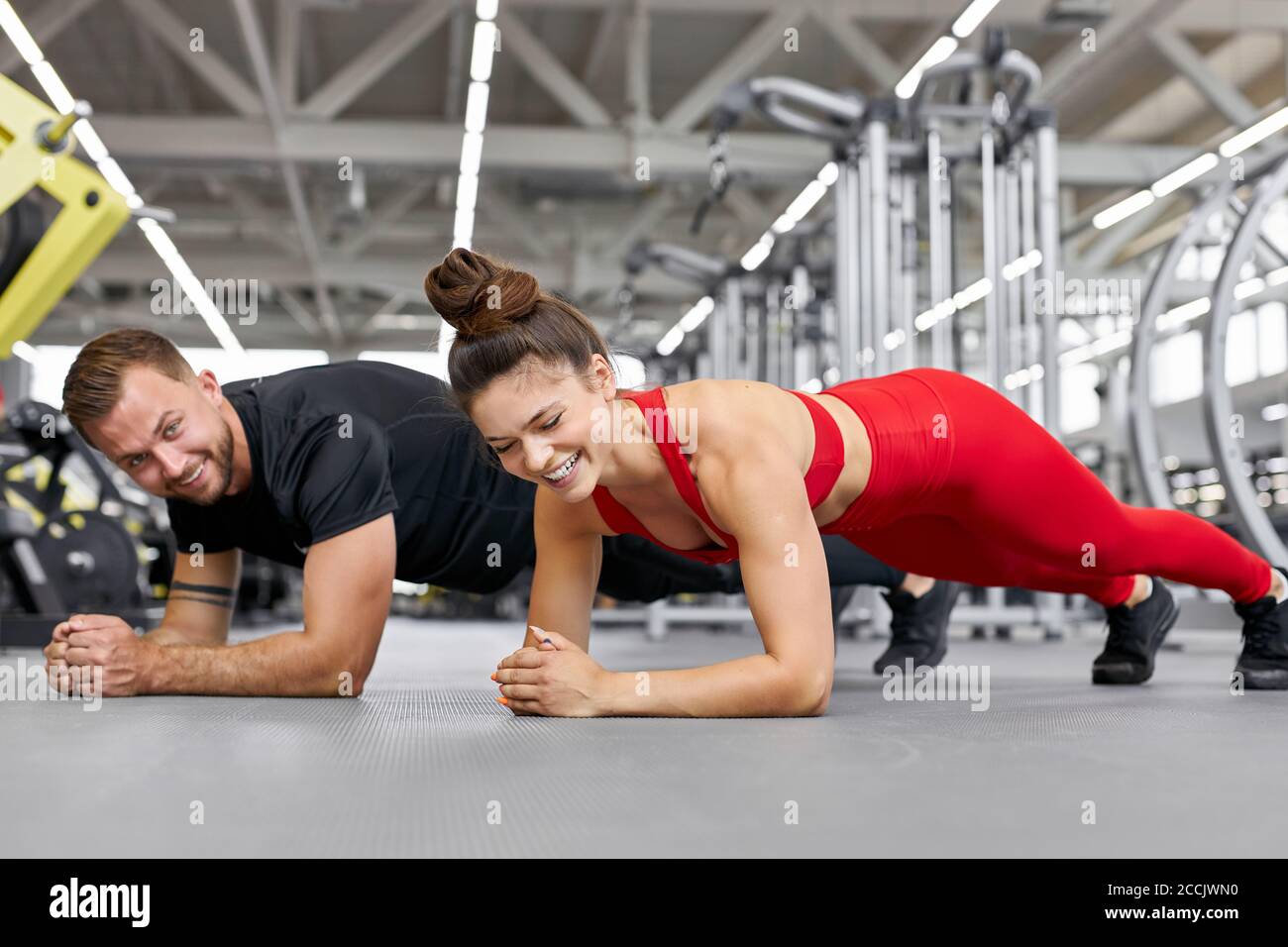 young caucasian man and woman athletes doing push-ups during cross ...