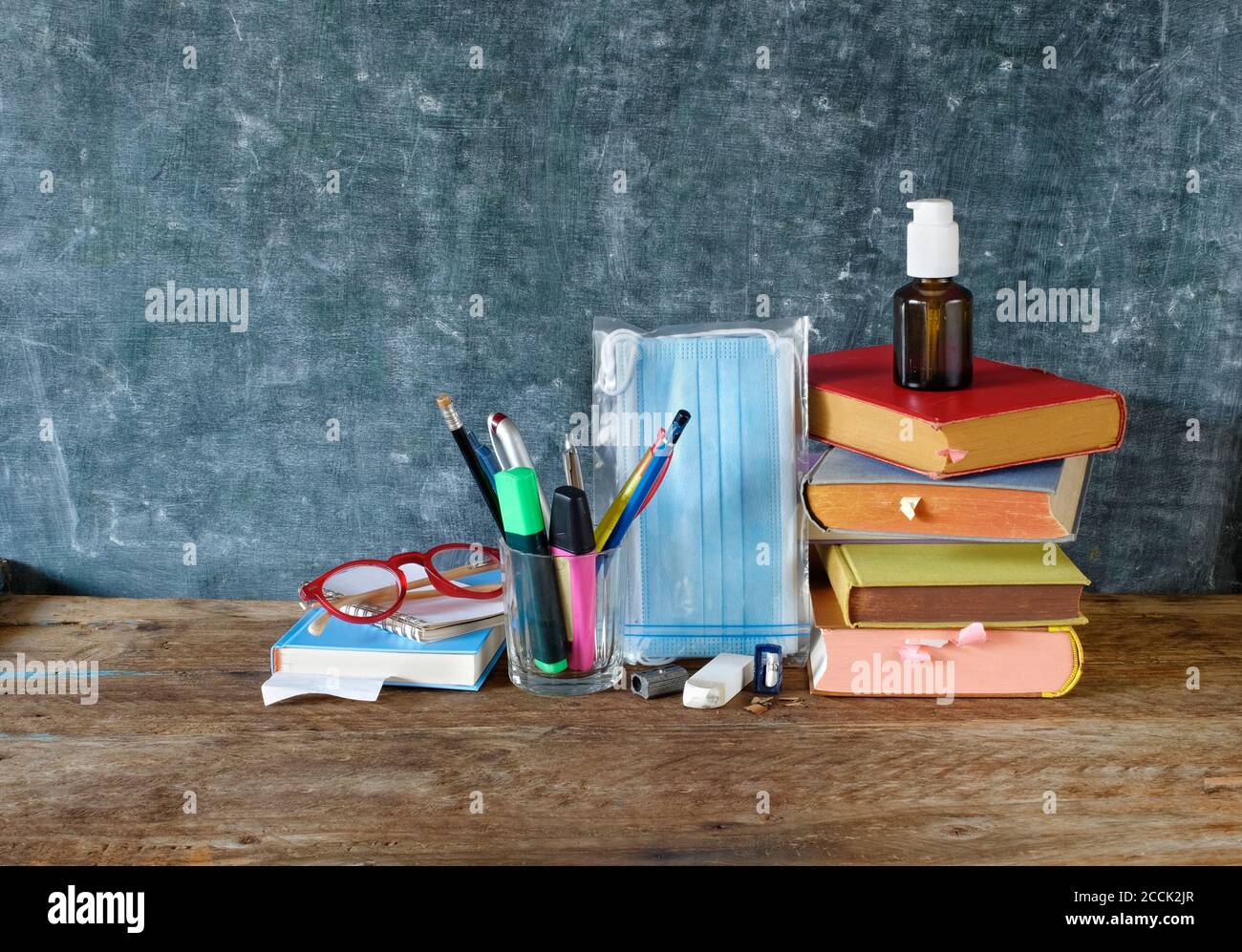 School supplies and COVID 19 prevention items on classroom desk with ...