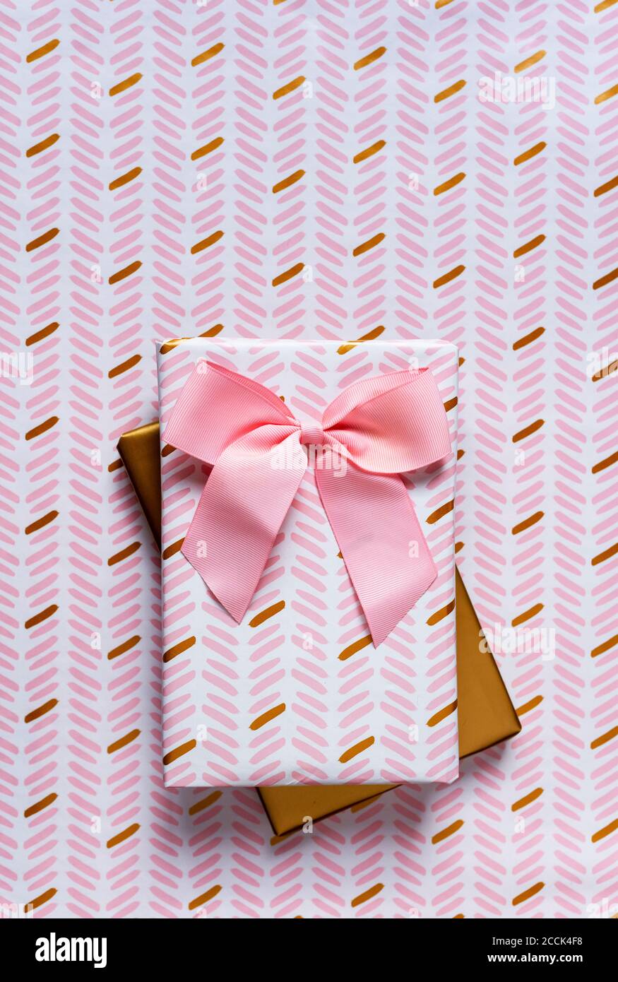 Two wrapped gifts against wrapping paper background Stock Photo - Alamy