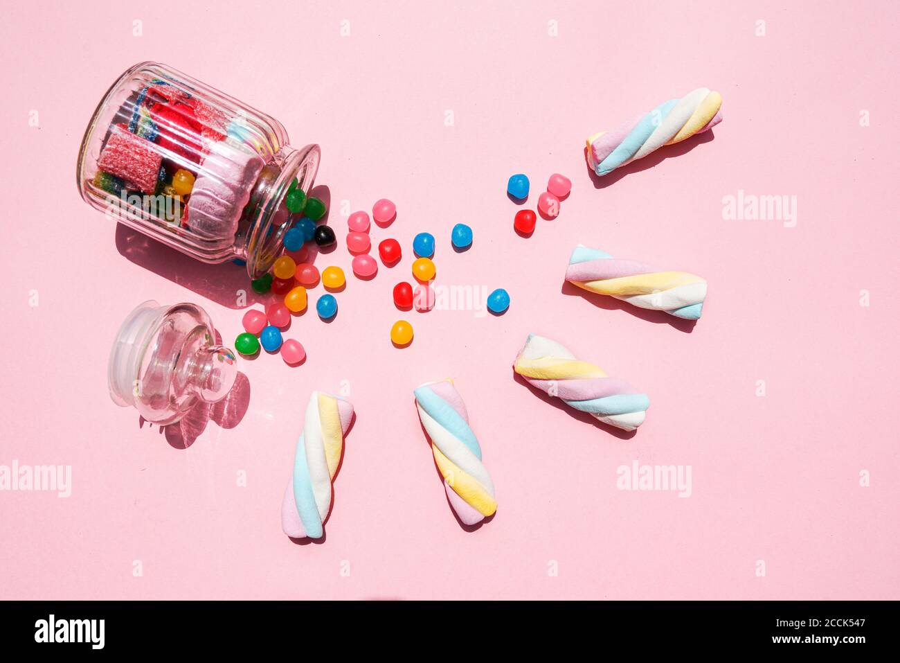 Studio shot of twisted marshmallows and candies spilling out from ...