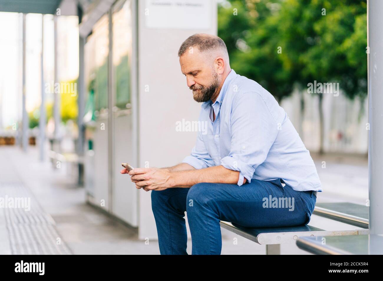 Using smart phone on urban bench hi-res stock photography and images ...