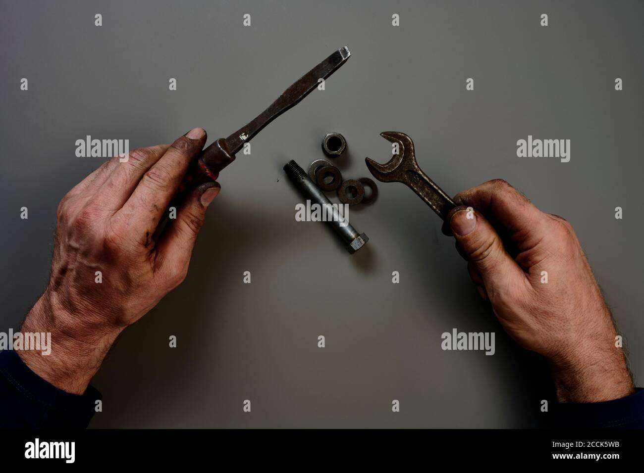 Top view of hand with tools in front of grey background Stock Photo - Alamy