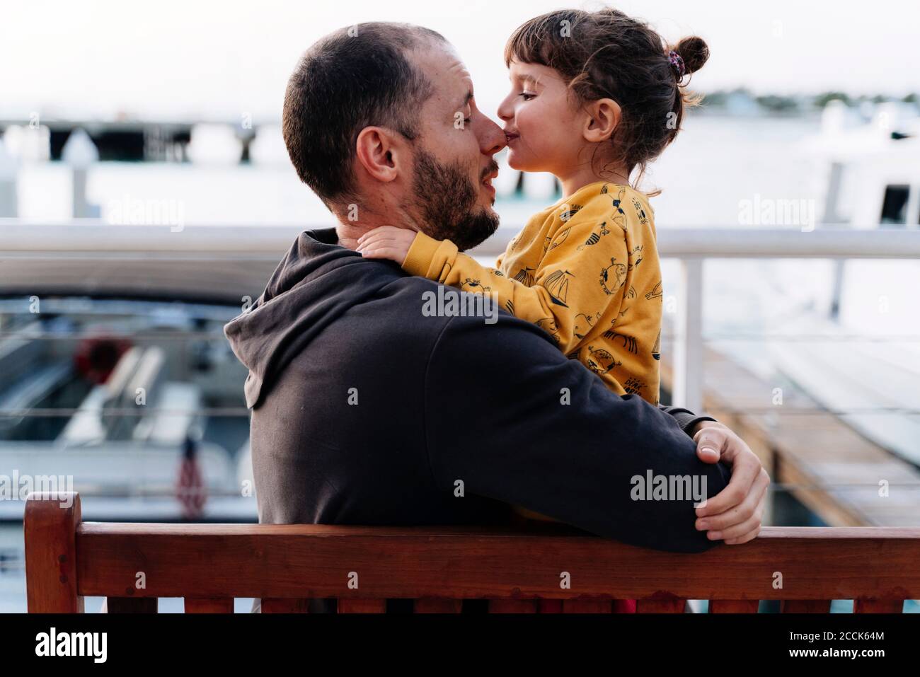 Father embracing while daughter kissing him on nose in city Stock Photo ...