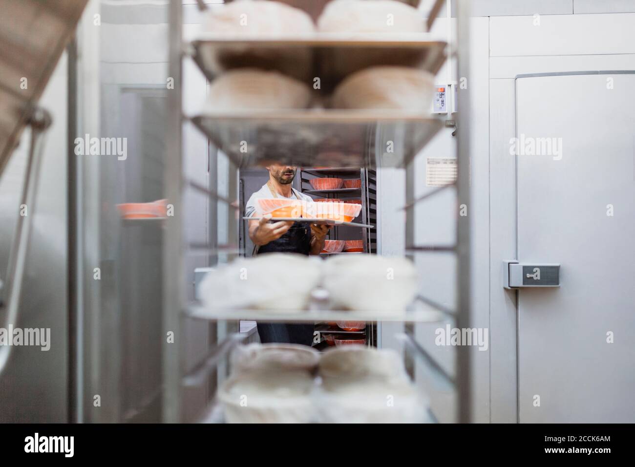 Baker working in commercial kitchen at bakery Stock Photo - Alamy