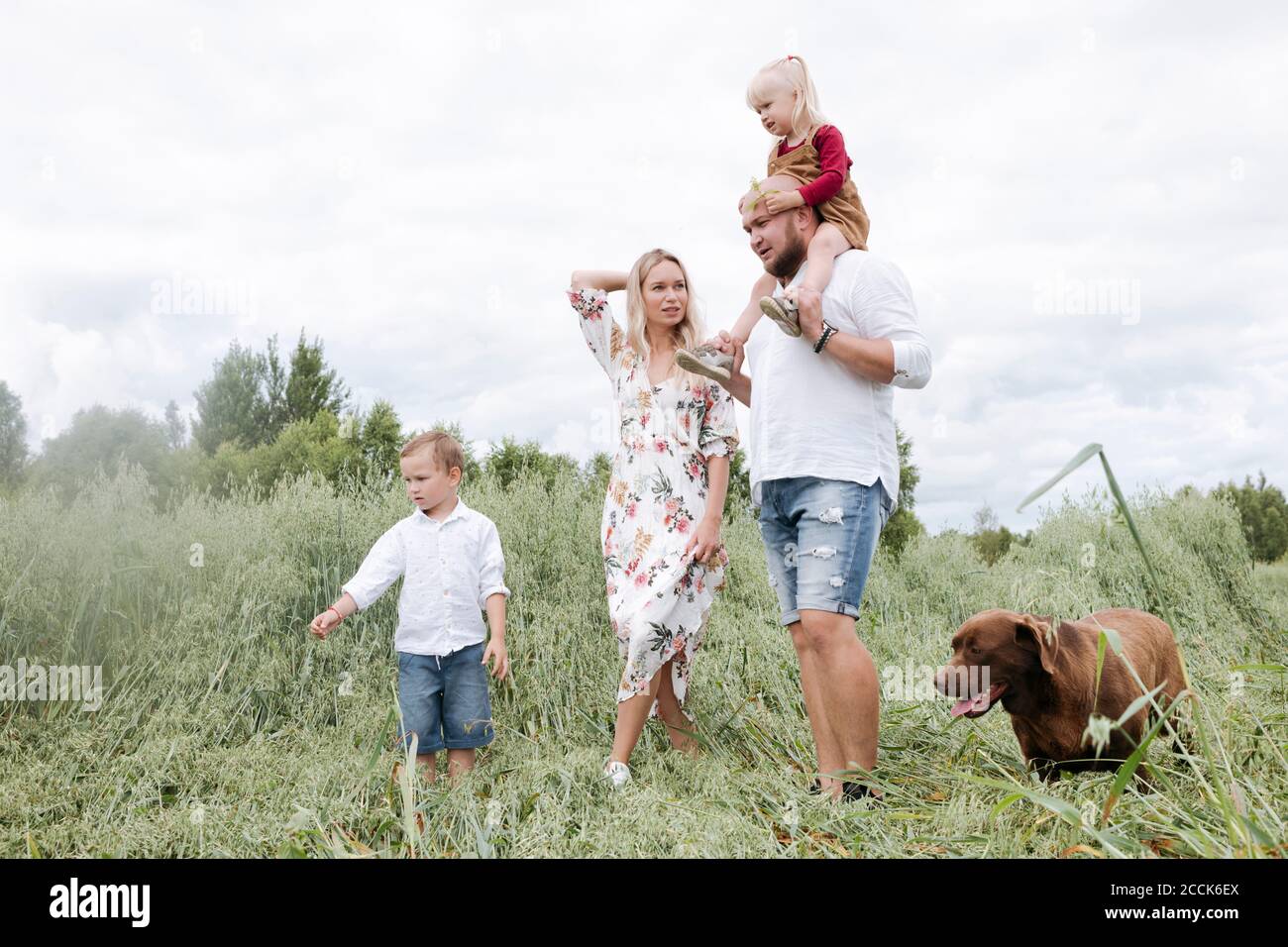 Man carrying daughter on shoulders while walking with family and ...