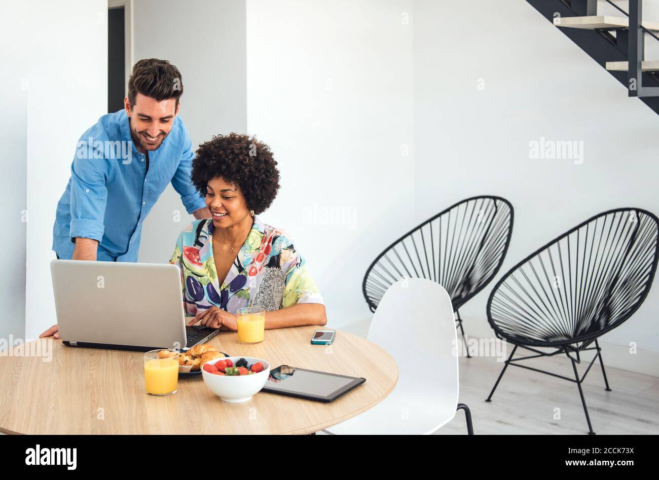 Happy couple using laptop in the kitchen at home Stock Photo - Alamy