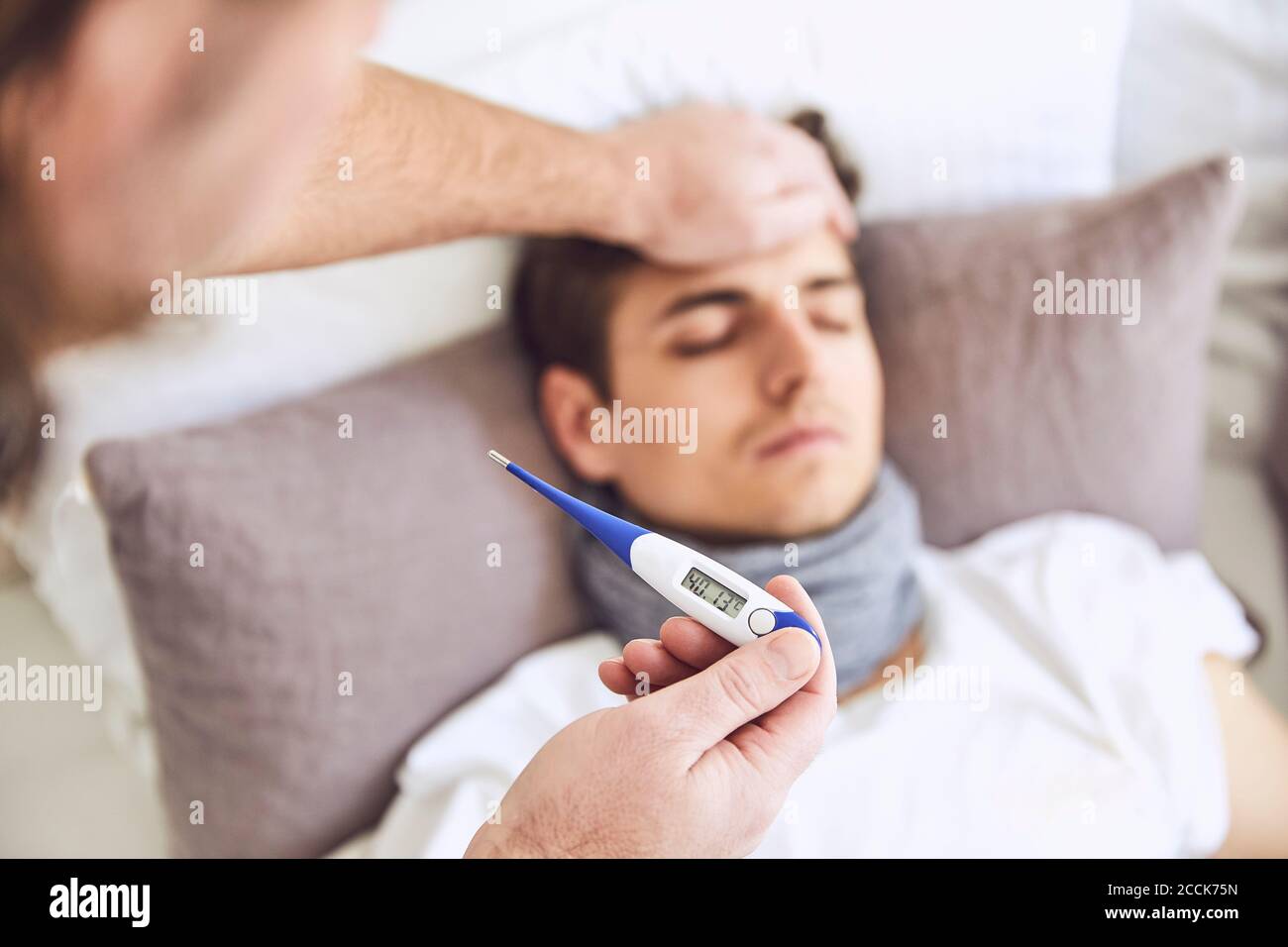 Close-up of doctor examining patient's temperature sleeping on bed at ...