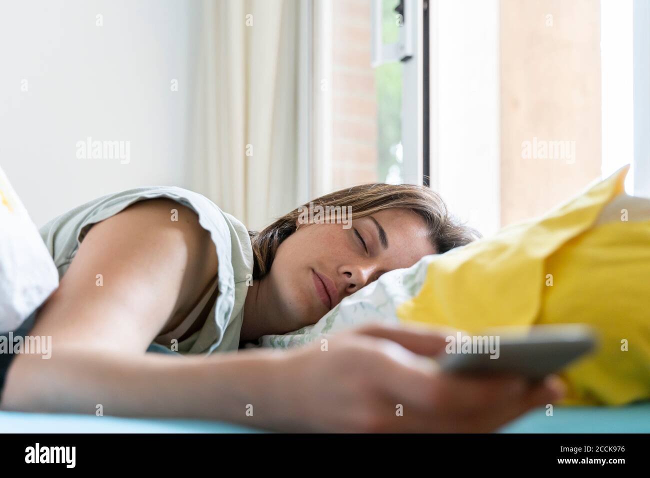 Woman with smart phone sleeping in bedroom Stock Photo - Alamy
