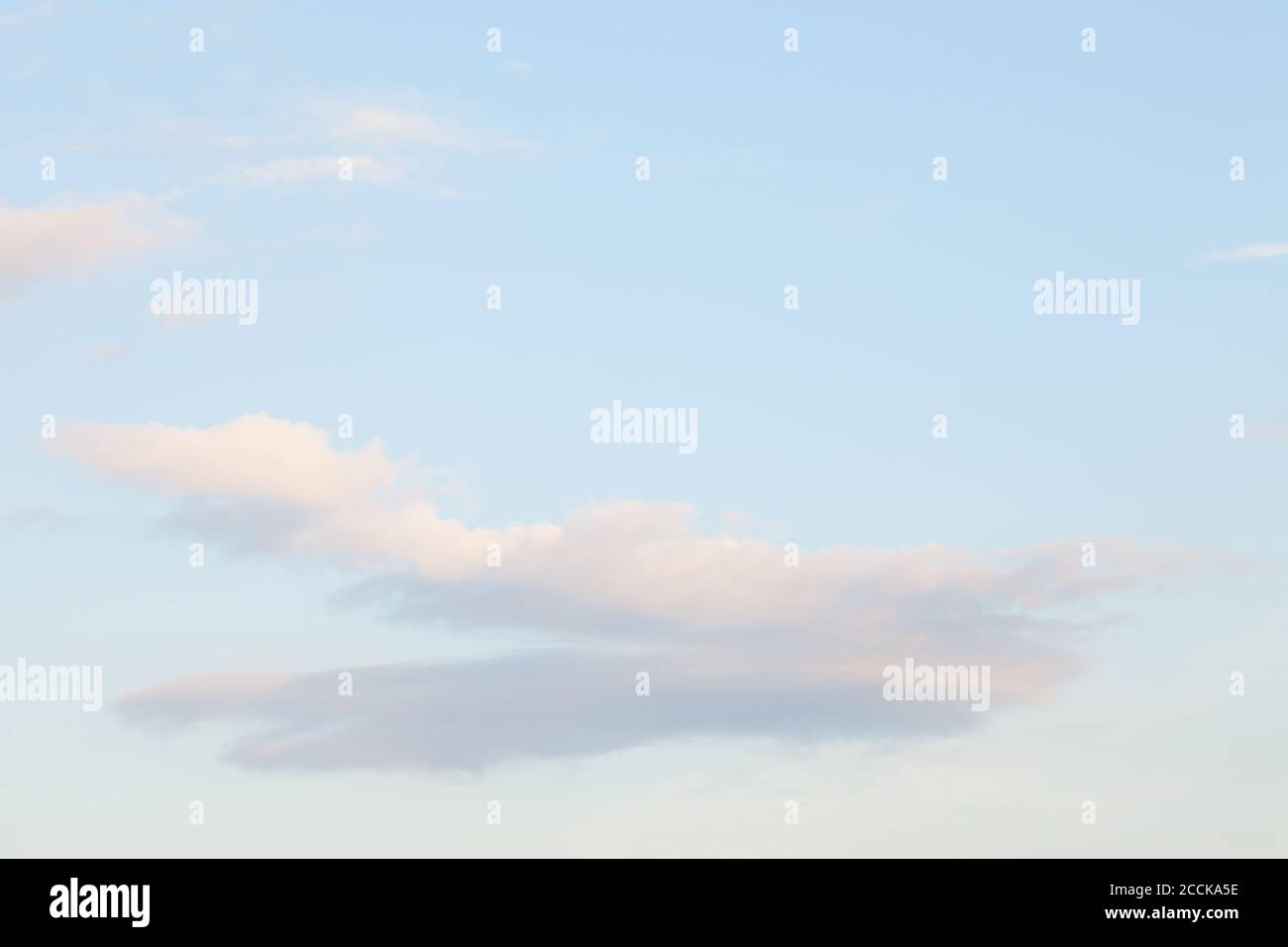 Background of pure light blue sky with a light pink cloud as a pattern ...