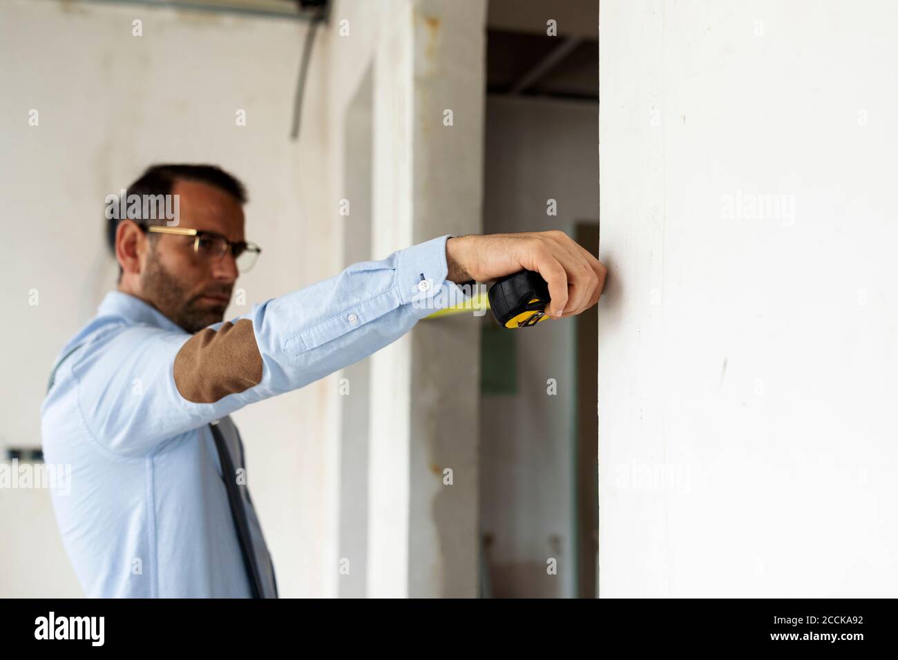 Architect using tape measure in a house under construction Stock Photo ...
