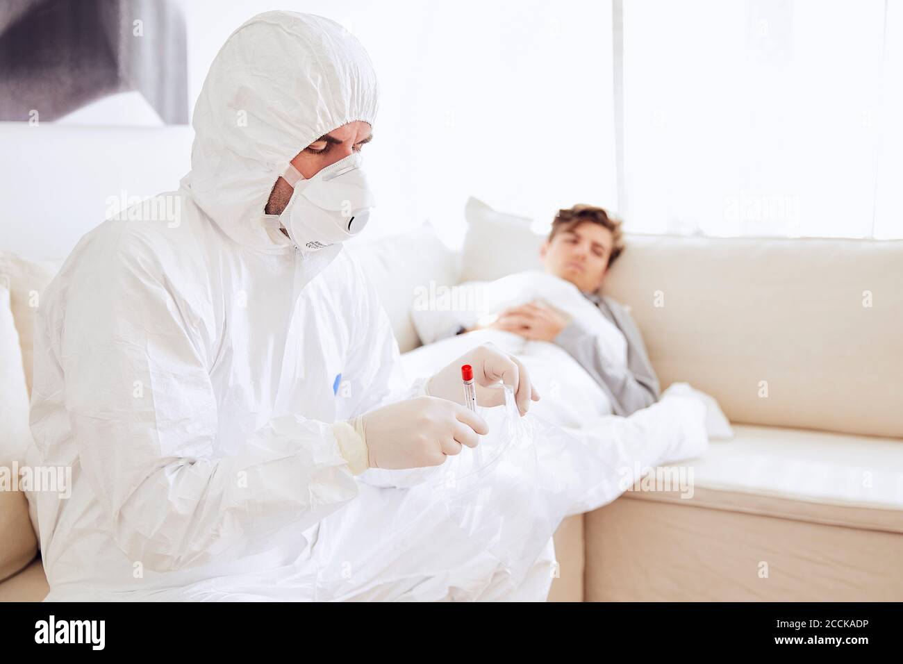 Doctor putting medical sample in plastic bag while patient resting at ...