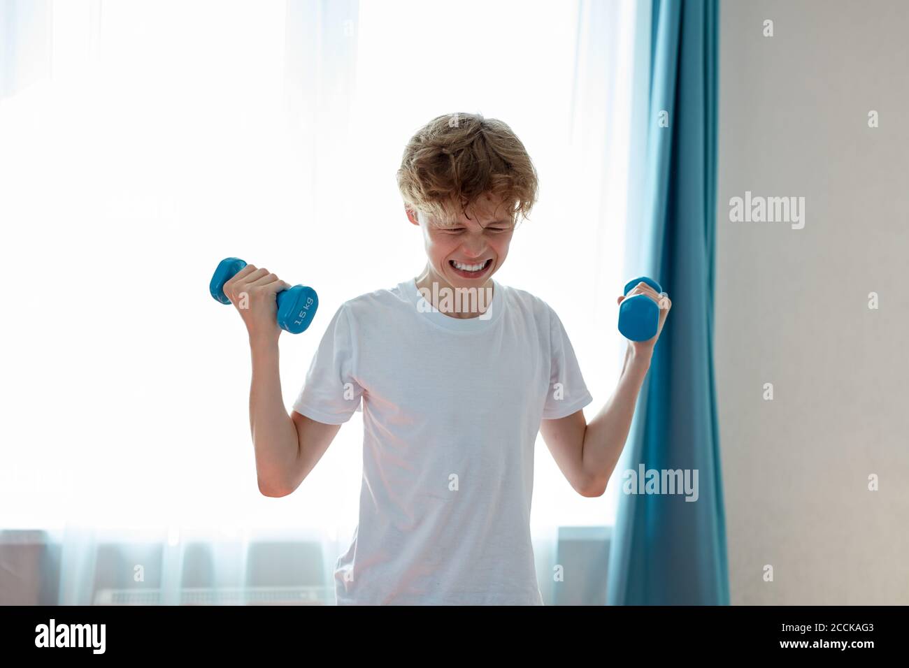 sportive child boy exercising with dumbbells at home, young caucasian ...