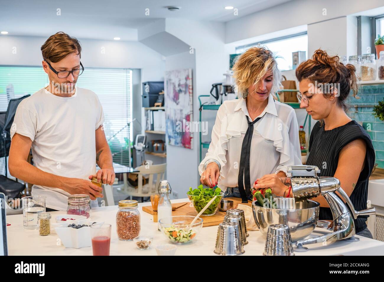 Chef teaching male and female students at cooking school Stock Photo ...