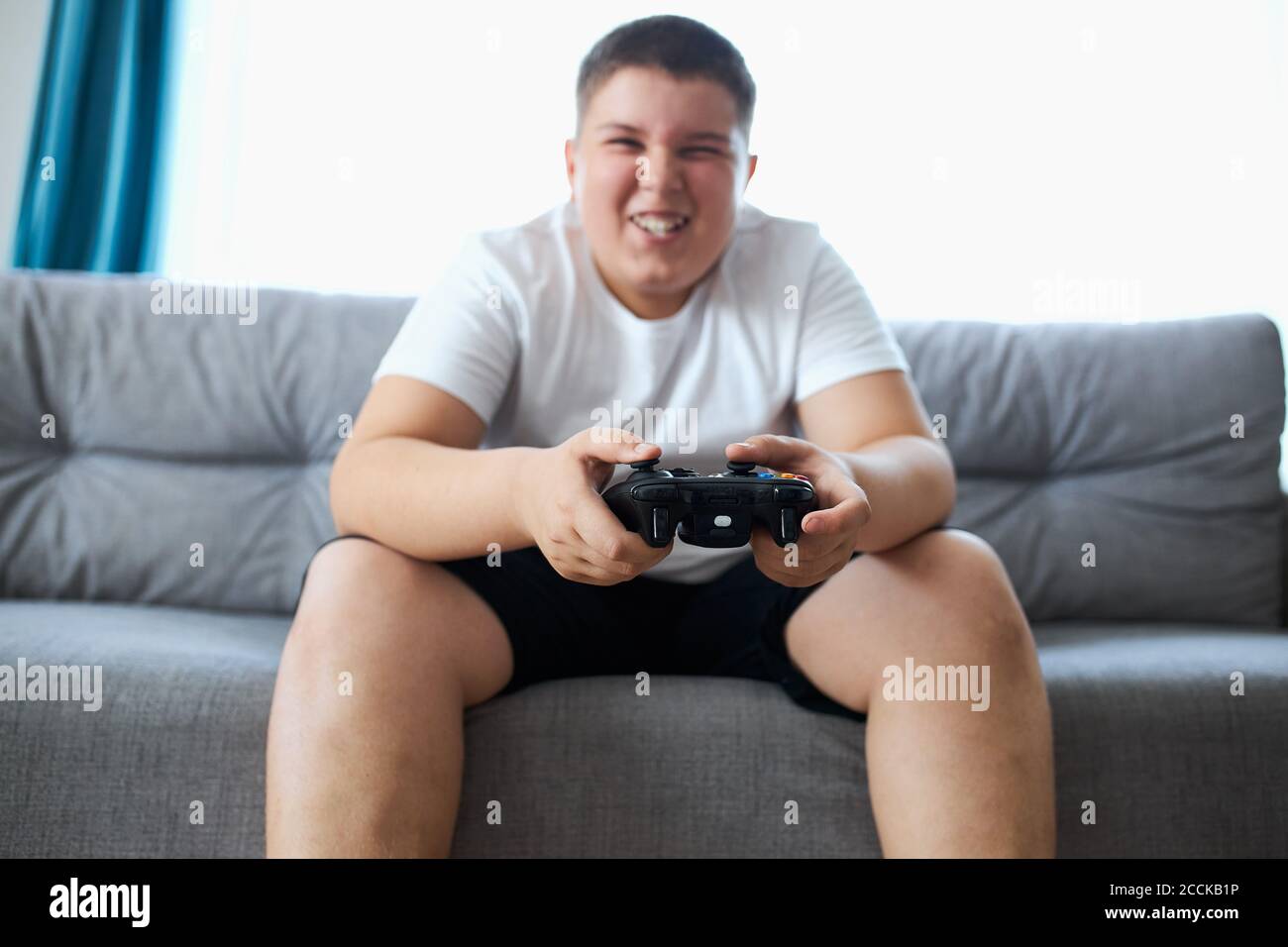 fat caucasian teenager boy enjoys video games, overweight boy sits on ...