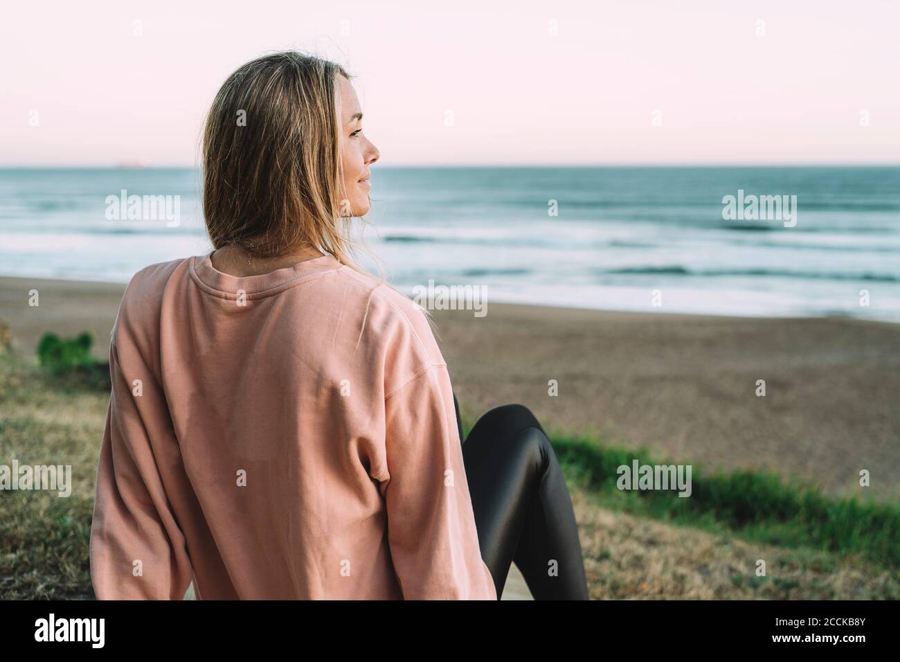 Woman sitting on beach back view hi-res stock photography and images ...