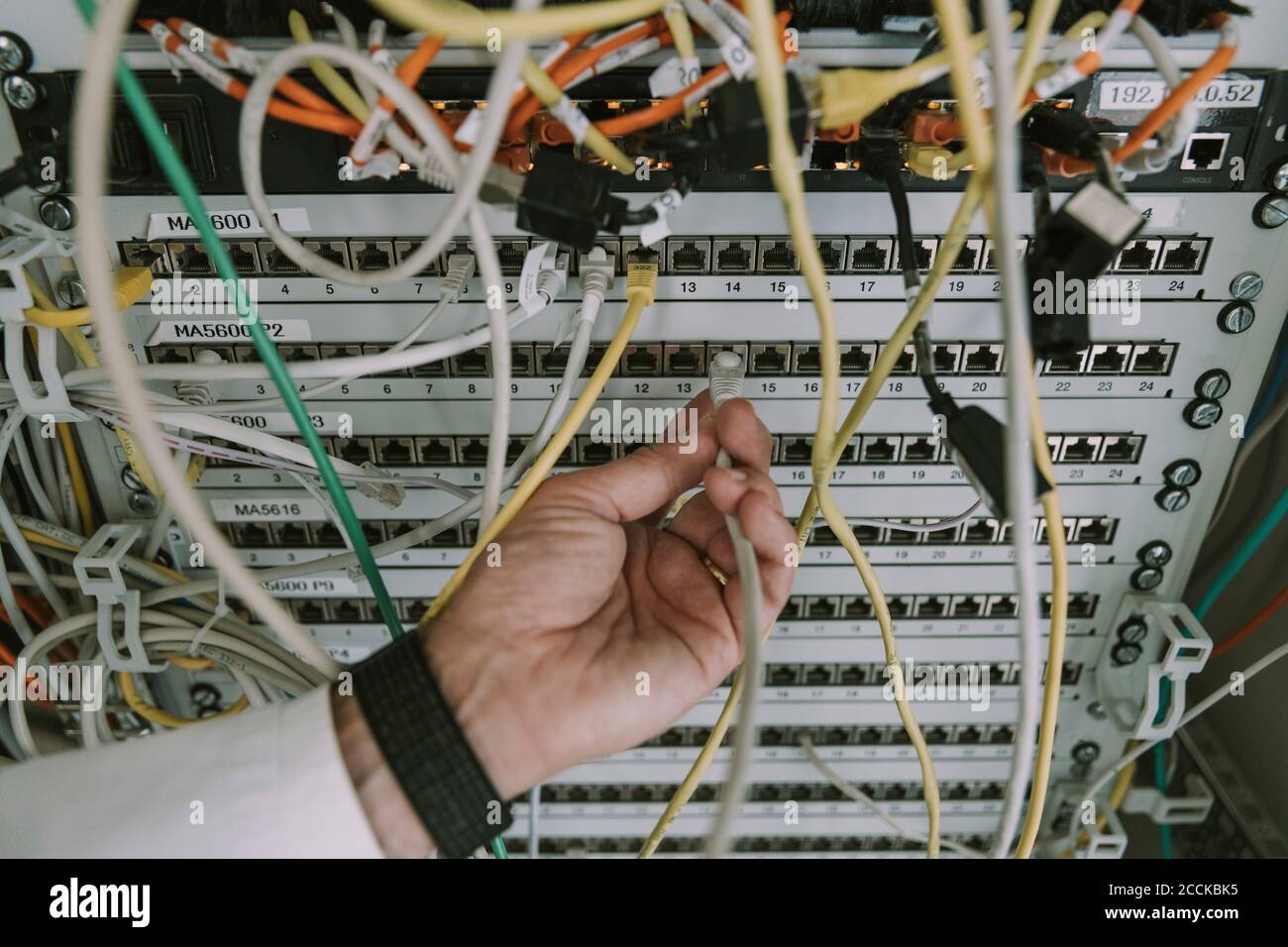 Close-up of hand plugging in cable in data center rack Stock Photo - Alamy