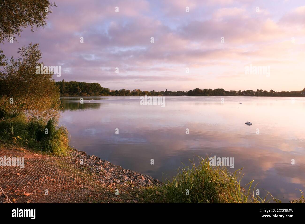 Beautiful sunset over a lake. Magnificent landscape with a dirt road ...