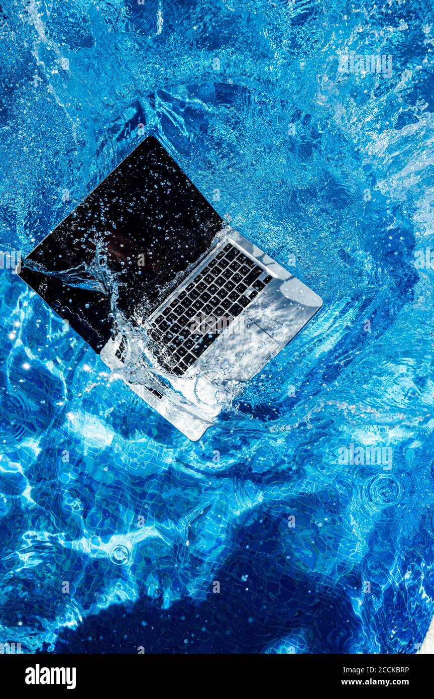 High angle view of computer falling in swimming pool Stock Photo - Alamy