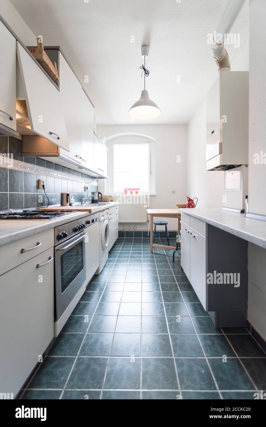 Clean apartment kitchen with tiled floor Stock Photo - Alamy