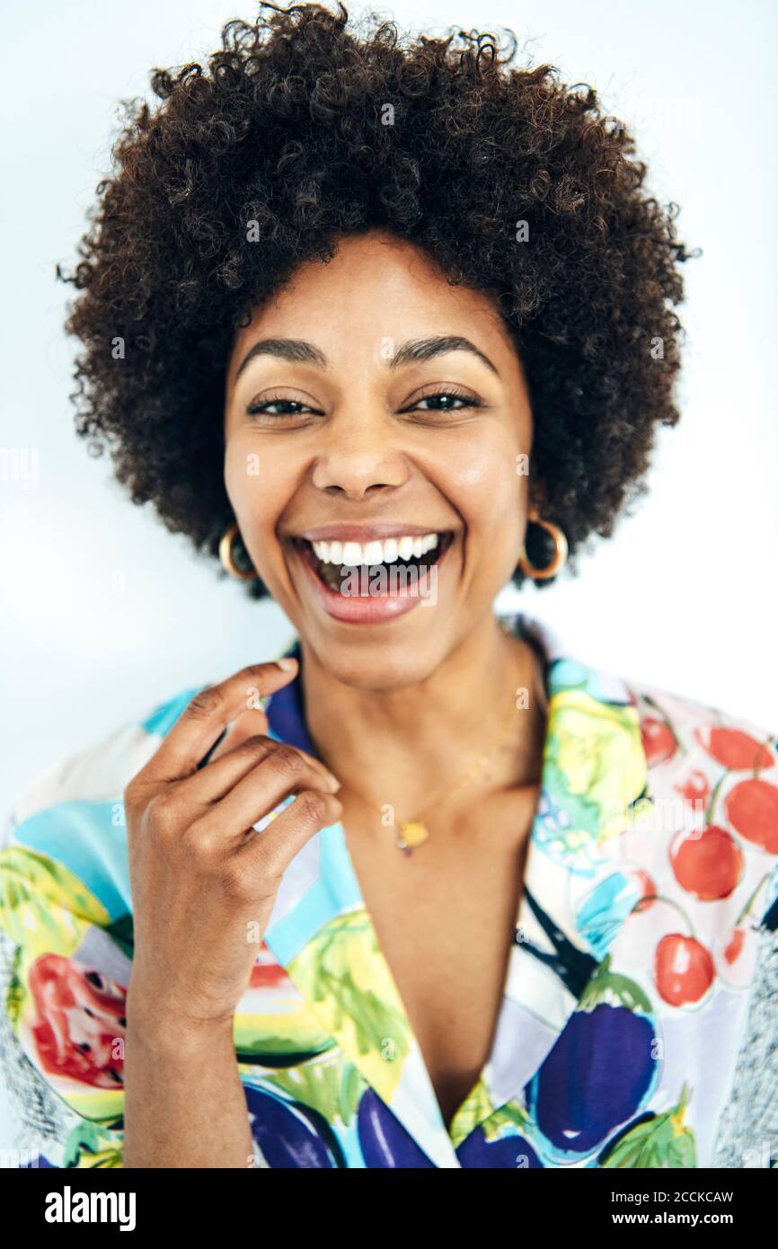 Cheerful mid adult woman with afro hairstyle against white background ...