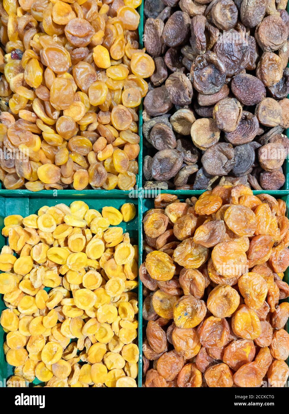 Dried apricots of four different types in a tray for sale on the market ...