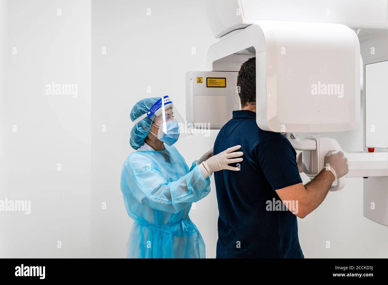 Female nurse helping male patient in scanning at hospital Stock Photo ...