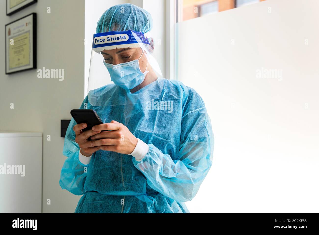 Female dentist texting through smart phone in clinic Stock Photo - Alamy