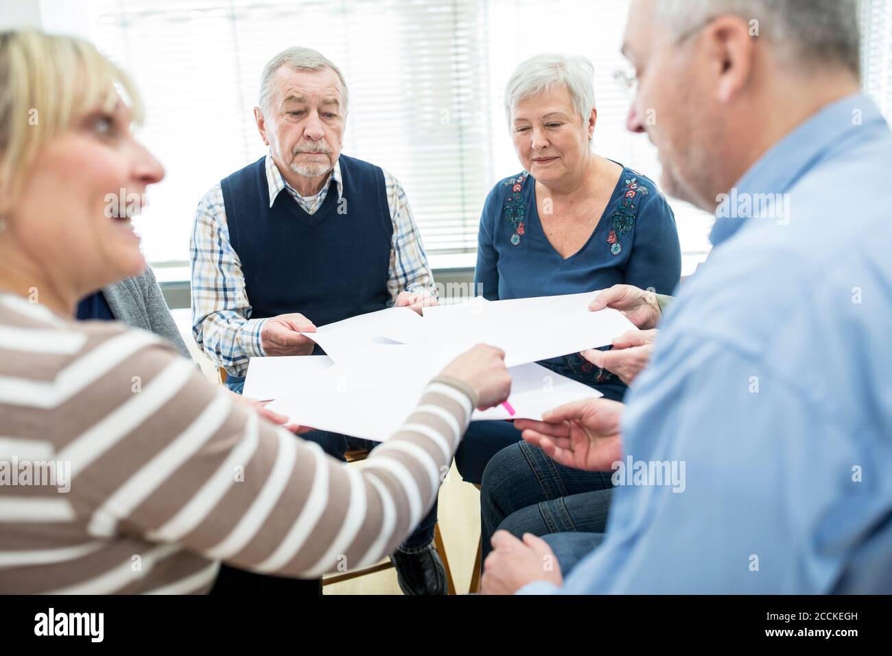 Group of seniors attending therapy group in retirement home, using ...