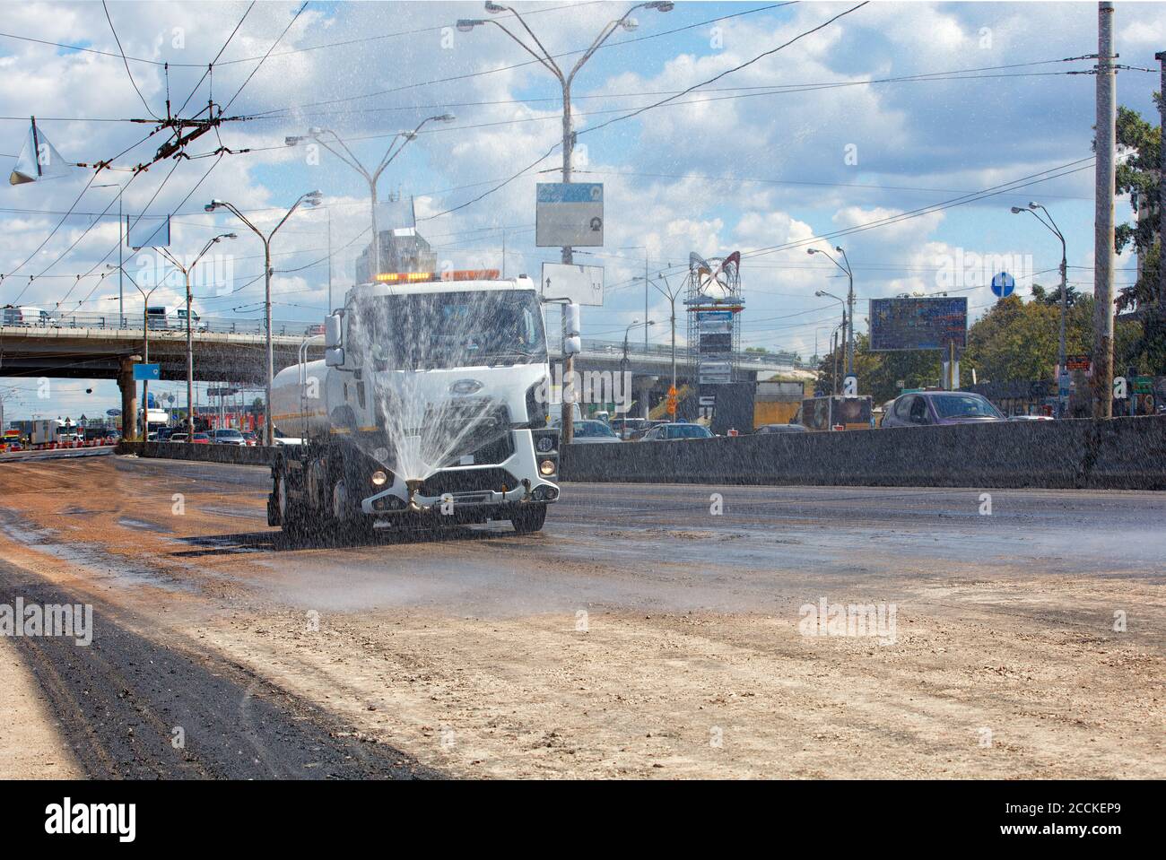 Watering machines on the street before the upcoming asphalting of a ...