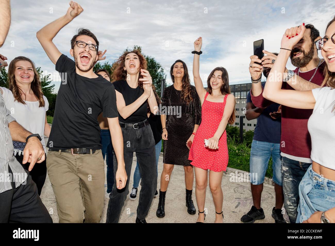 Cheerful friends screaming while standing on footpath in park Stock ...