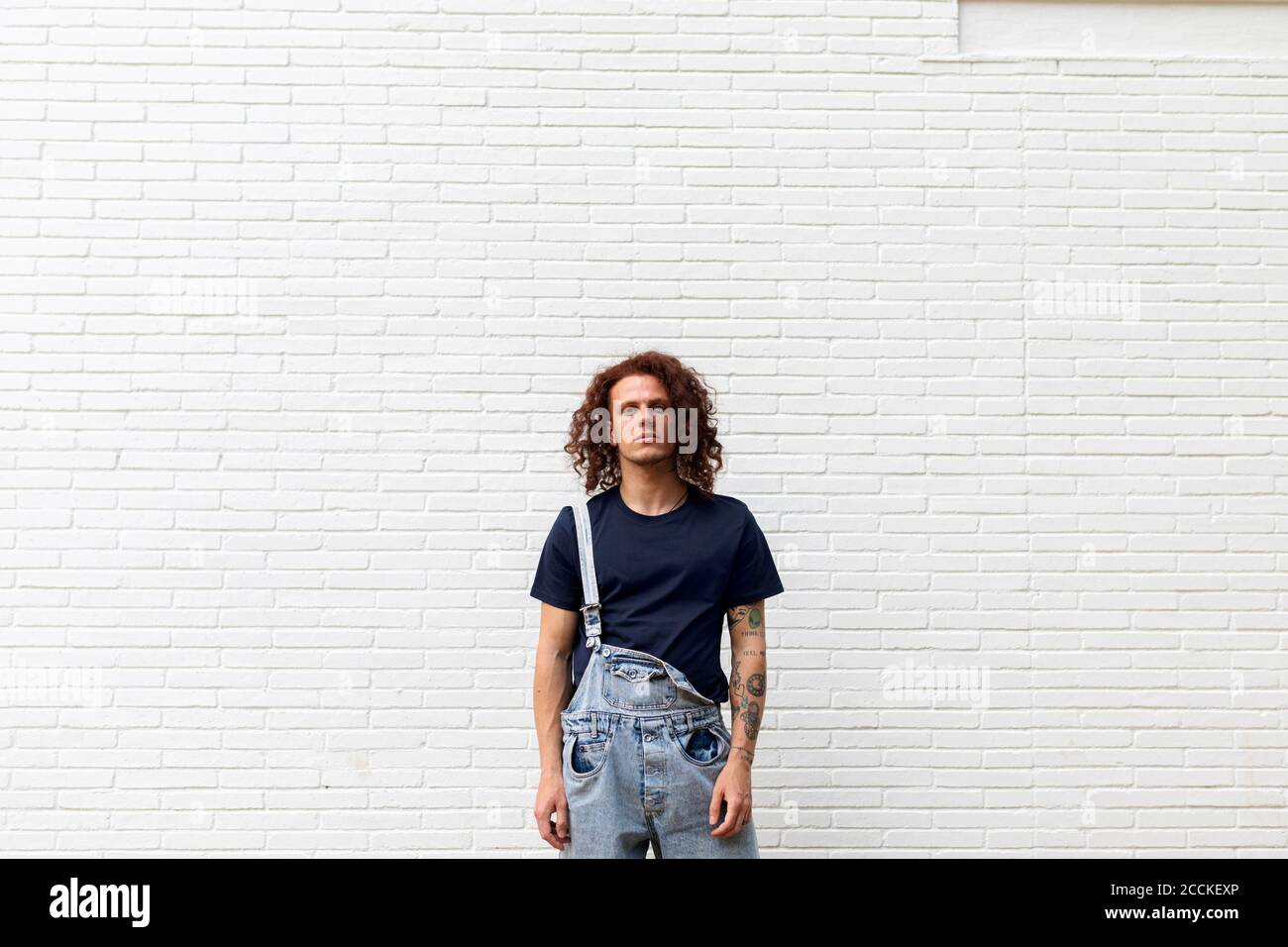 Portrait serious young man brick wall hi-res stock photography and ...
