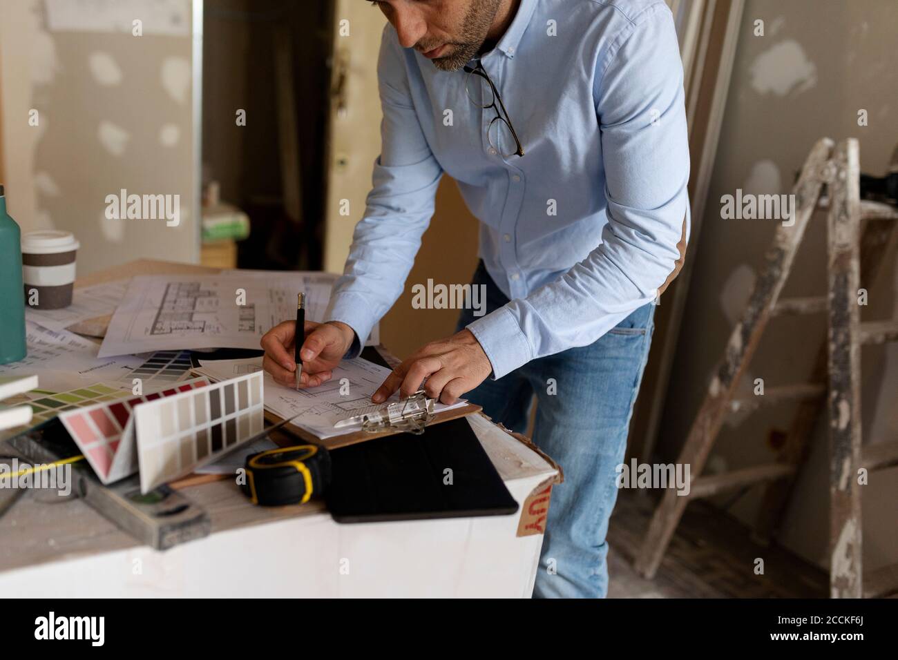 Architect at work with construction plan and colour swatch Stock Photo ...