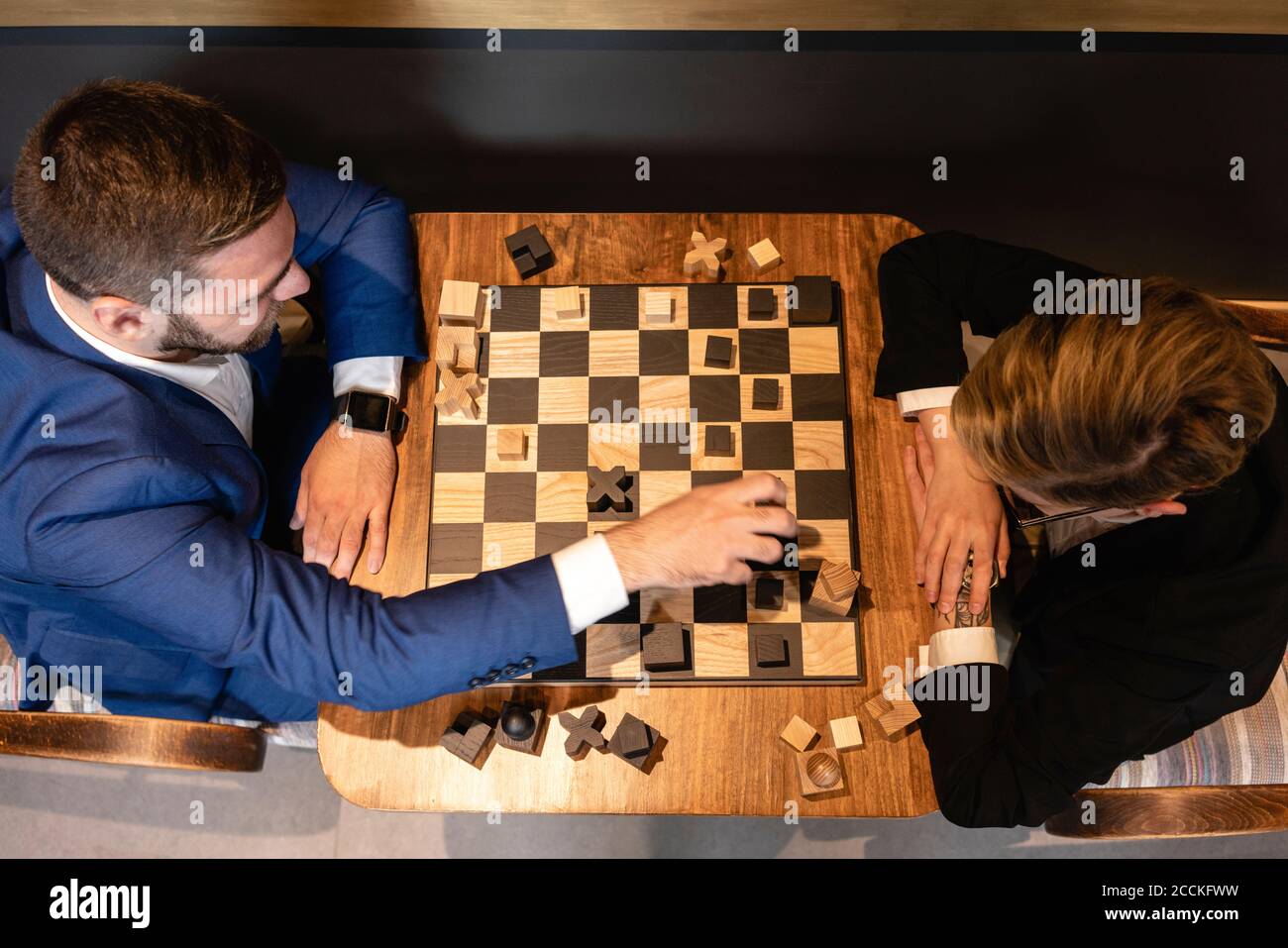 Male and female entrepreneur playing chess at creative office Stock ...