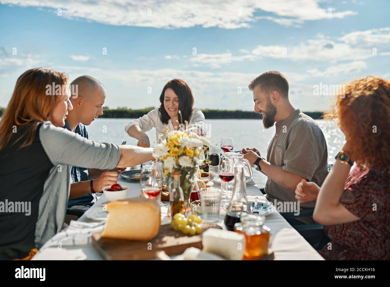 Friends having dinner at a lake Stock Photo - Alamy