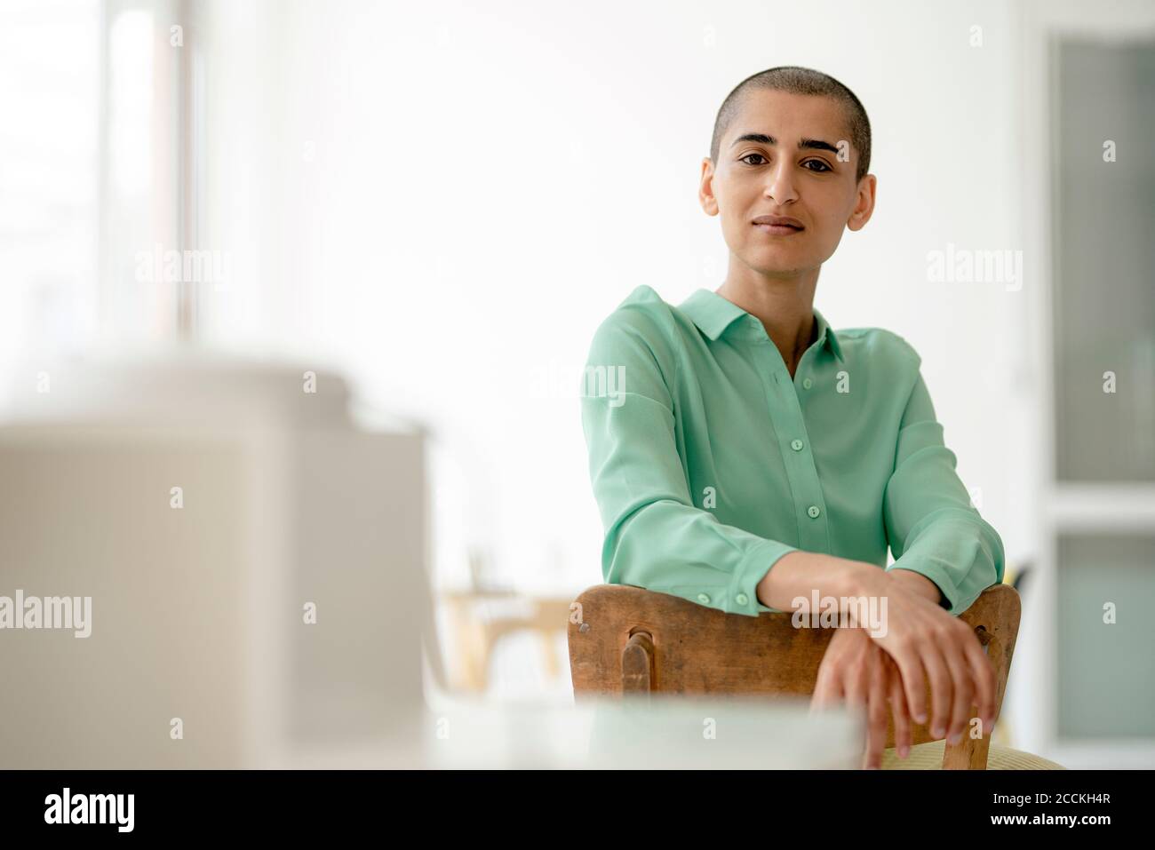 Portrait of a confident woman sitting on chair in a loft Stock Photo ...